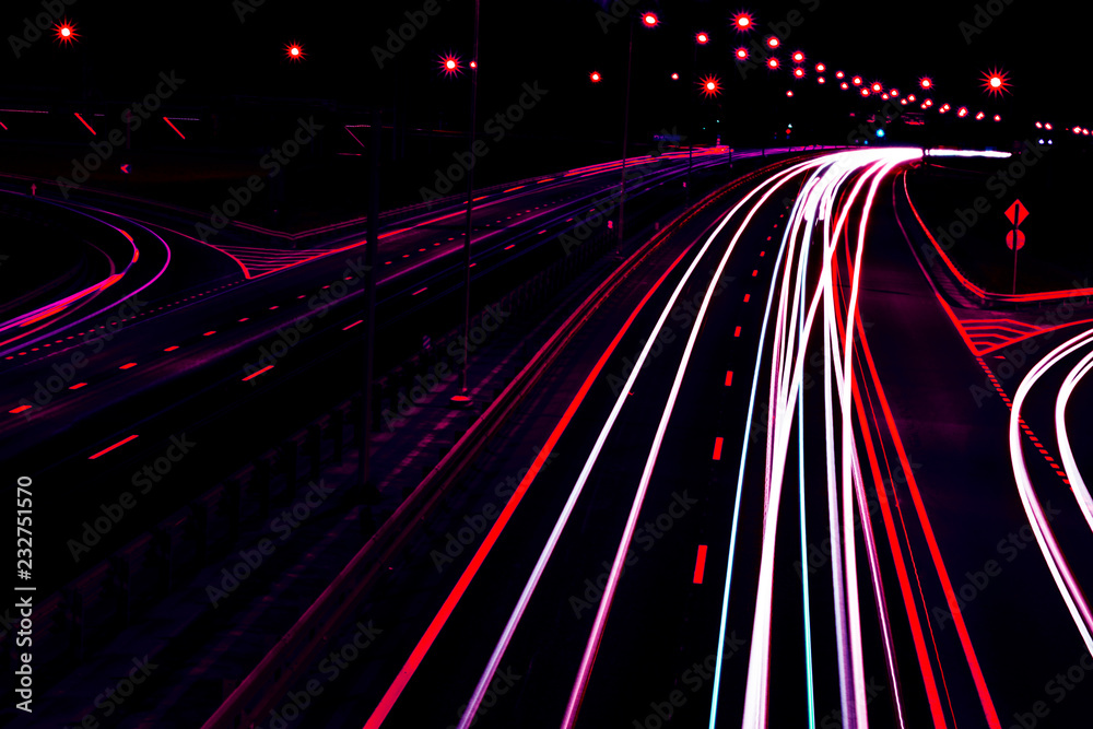 Cars light trails on a curved highway at night. Night traffic trails ...
