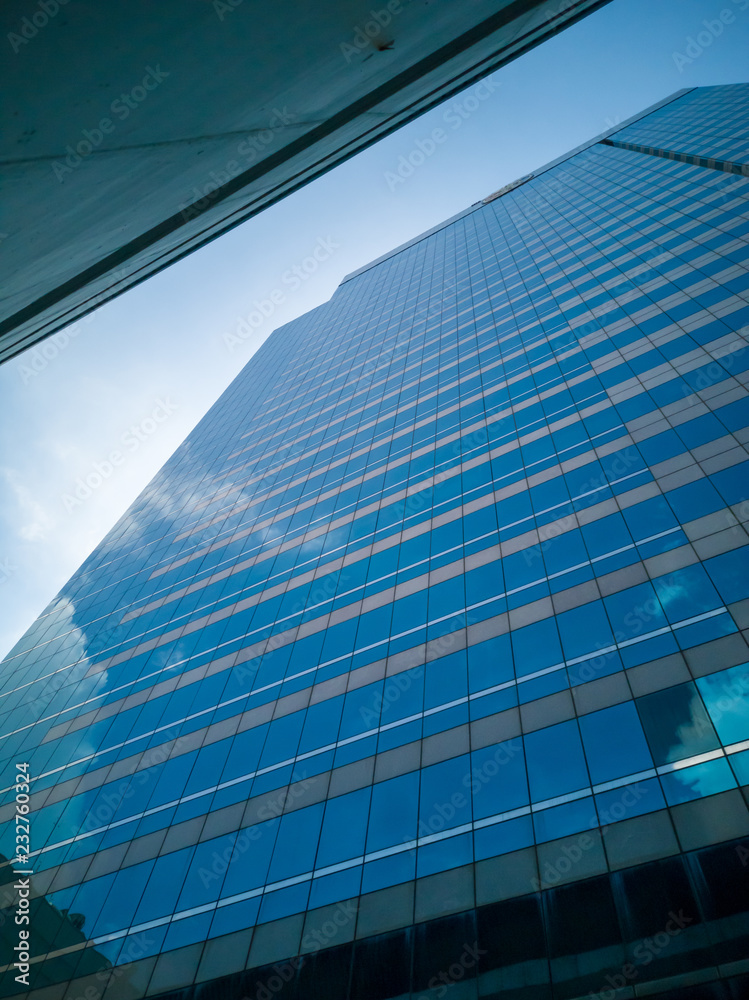 Mirror reflection of tall buildings.Shadow reflects the white clouds ...