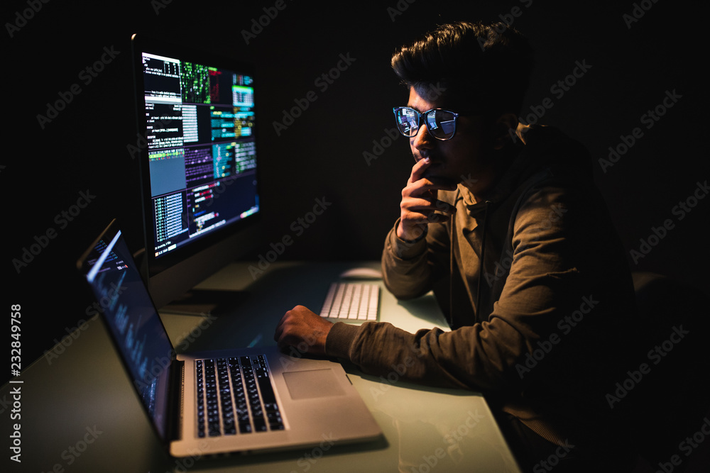 Hacker in glasses breaking code. Criminal hacker penetrating network ...