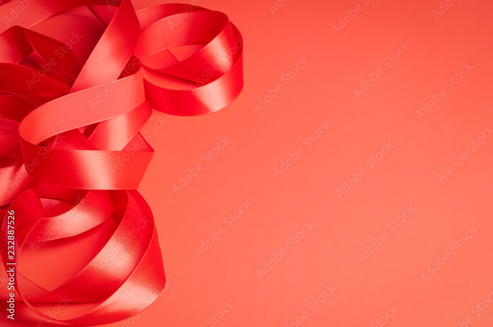 An artistic and flowing swirl of medium-width shiny red satin ribbon ...