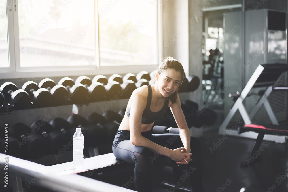 Fit asian woman sitting and relax after the training session in gym ...