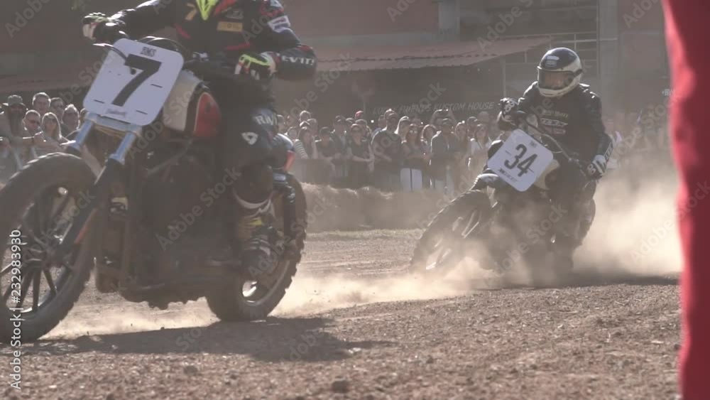 motorcycle riders passing finish line on dirt racing track on daylight ...