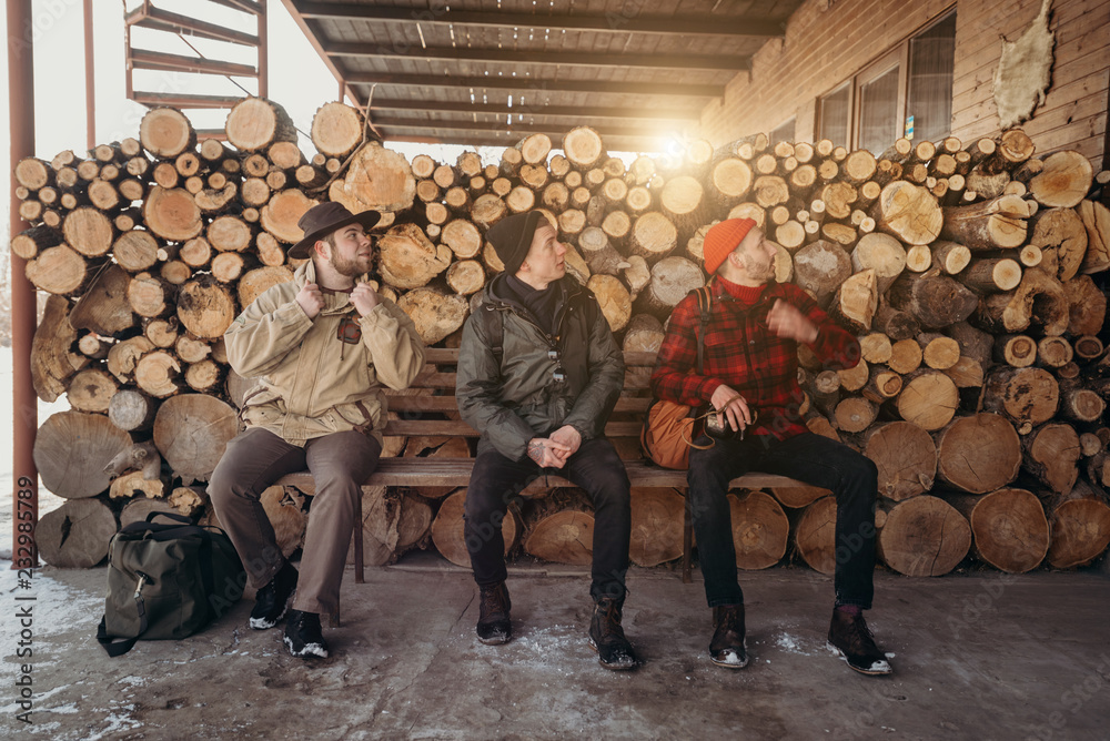 Strong lumberjacks wearing in jackets on the bench on the background of ...