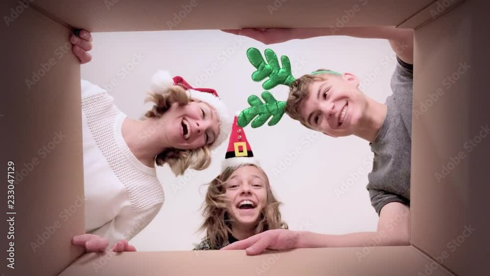 Happy Christmas family - mom, son and daughter opening cardboard box ...