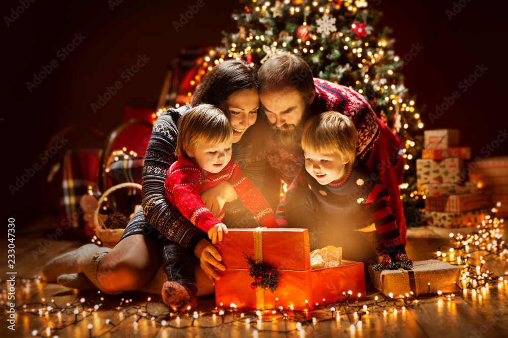 Foto de Christmas Family open Lighting Present Gift Box under Xmas Tree ...