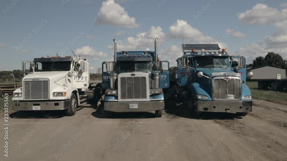 Three Semi Trucks parked side by side with all doors opening at the ...