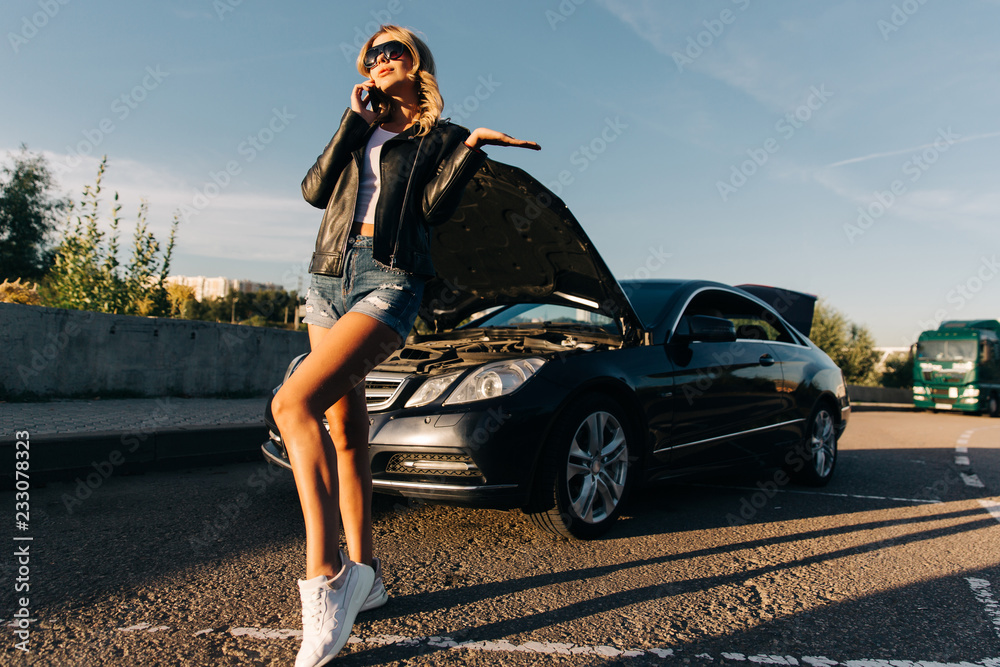 Full-length photo of woman standing in front of black car with open ...