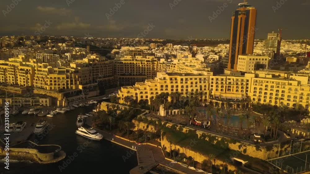 Beautiful golden light of sunrise shines on the buildings of San Giljan ...