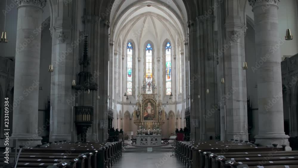inside praying hall of catholic cathedral with grey columns and stained ...