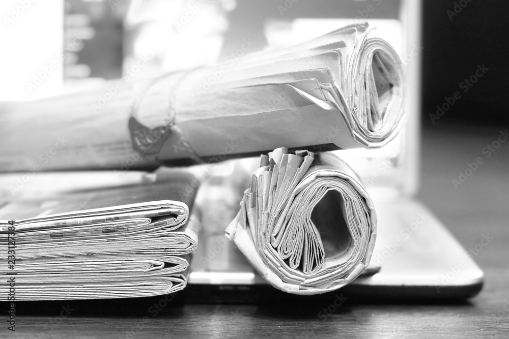 Newspapers and computer. Folded and rolled papers and magazines on ...