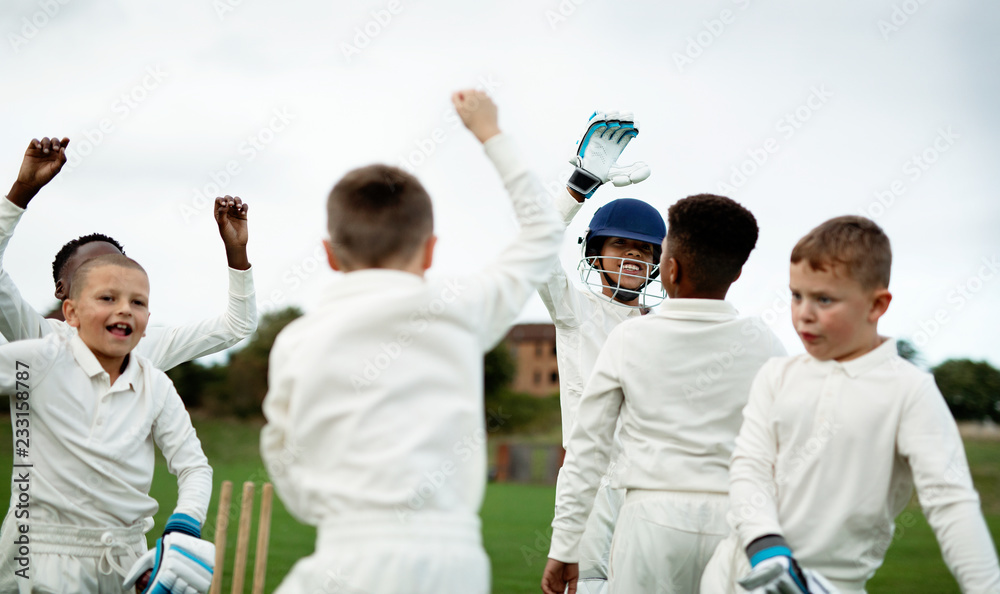 Young happy cricketers cheering on the field Stock Photo | Adobe Stock