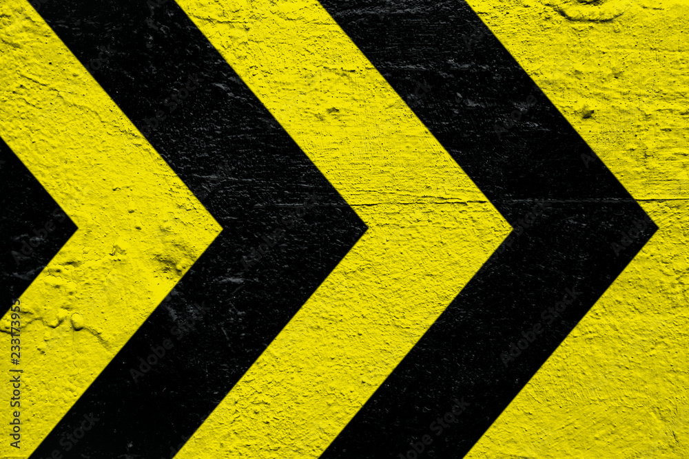Warning sign yellow and black stripes as arrows painted over concrete ...