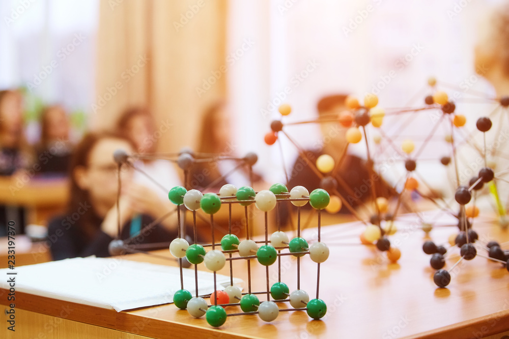 School children in a science class with a molecular model. Background ...