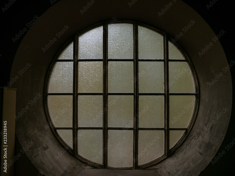 Old round window with interesting architecture in a dark room, low ...