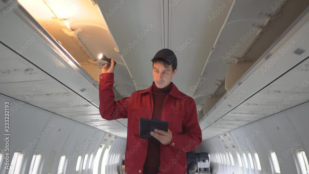 Repair of passenger aircraft cabin. Mechanic conducts inspection of the ...