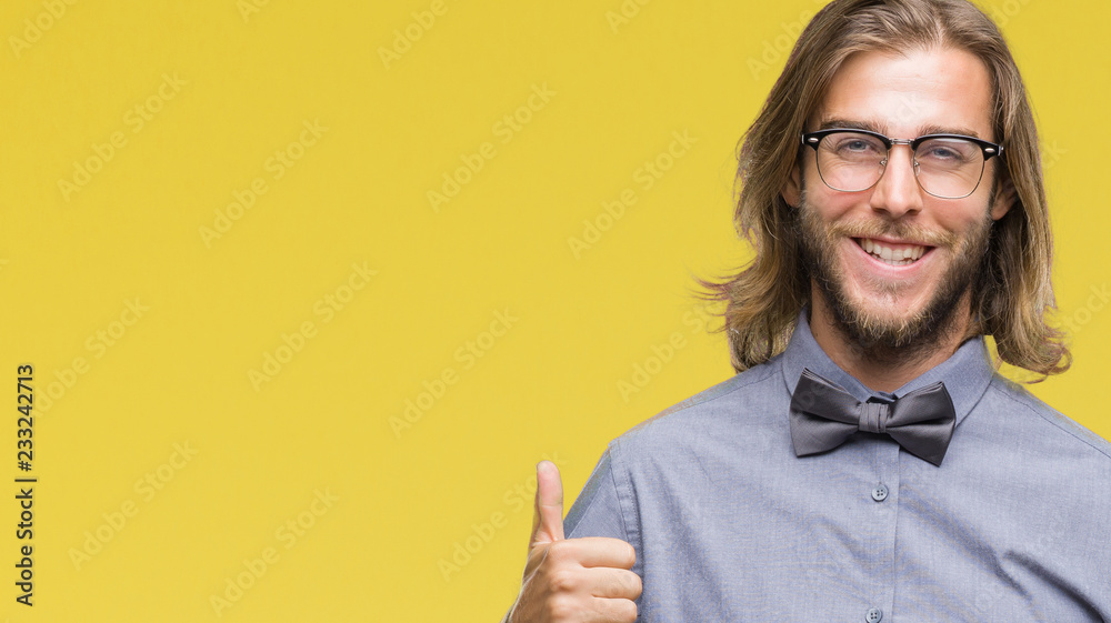 Young handsome man with long hair wearing bow tie over isolated ...