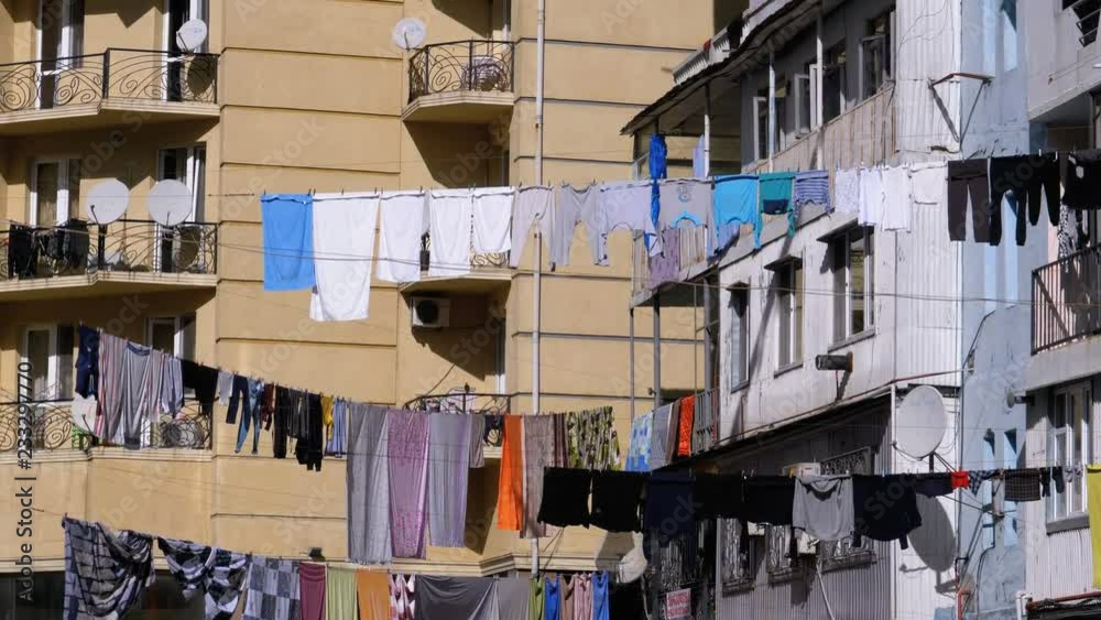 Clothes hanging and drying on a rope on a multi-story building in a ...