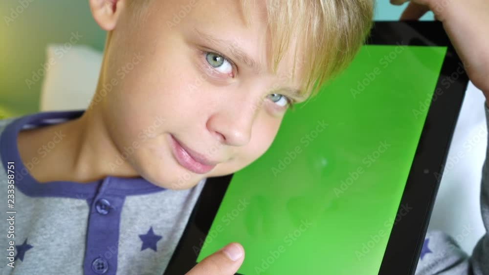 Closeup portrait of cute happy smiling little kid holding black tablet ...