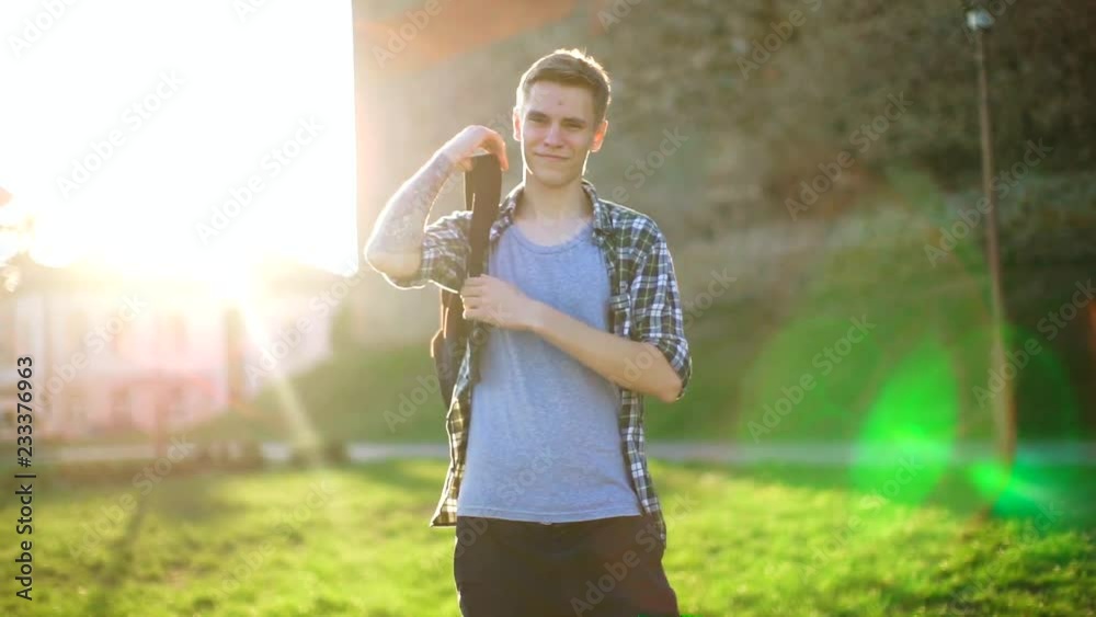 Handsome guy smiling in the sun.Guy model wears a backpack on his ...