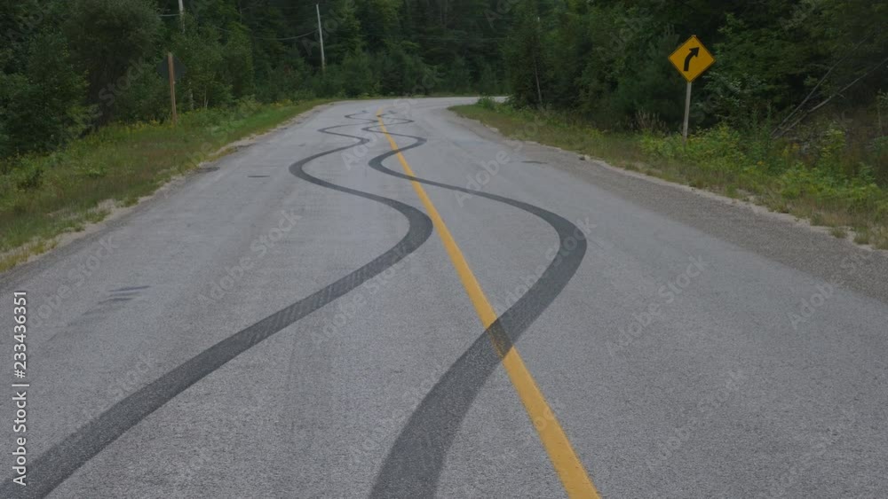 Skid marks on road from car doing a burnout. Tilt up. Haliburton ...