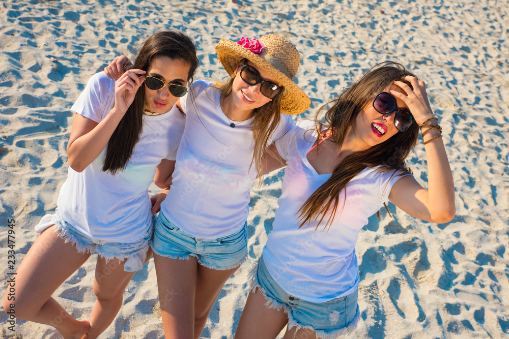Tres chicas sexys de blanco en la playa sobre la arena riendo y ...