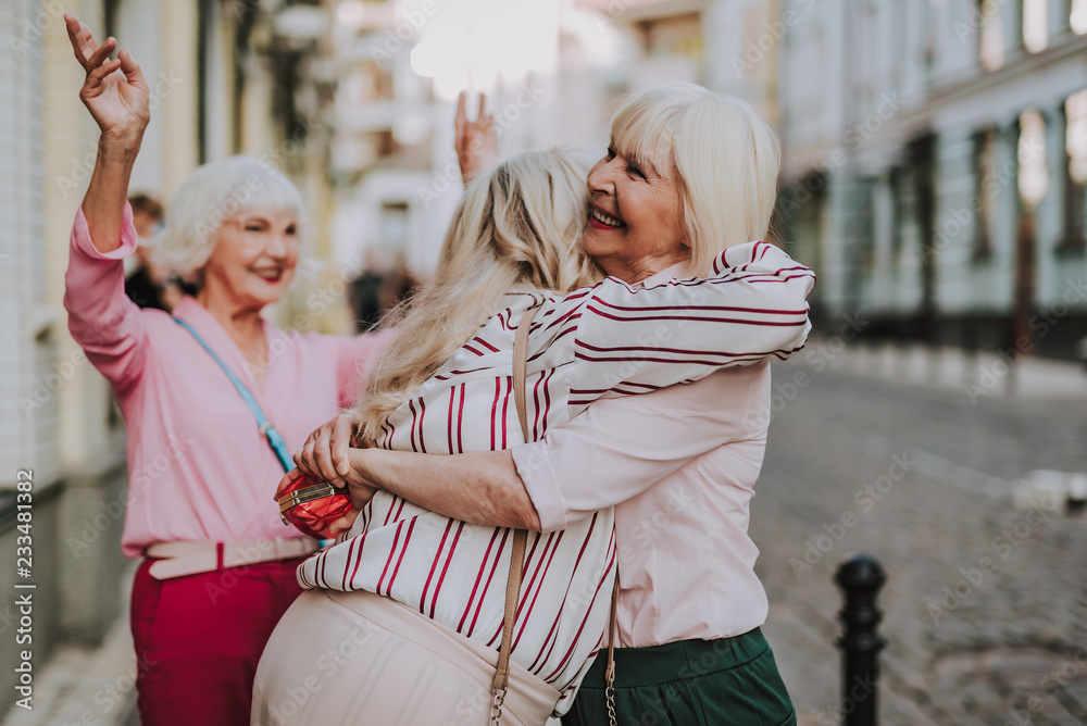 Waist up photo of three females a respectable age. Two friends hugging ...