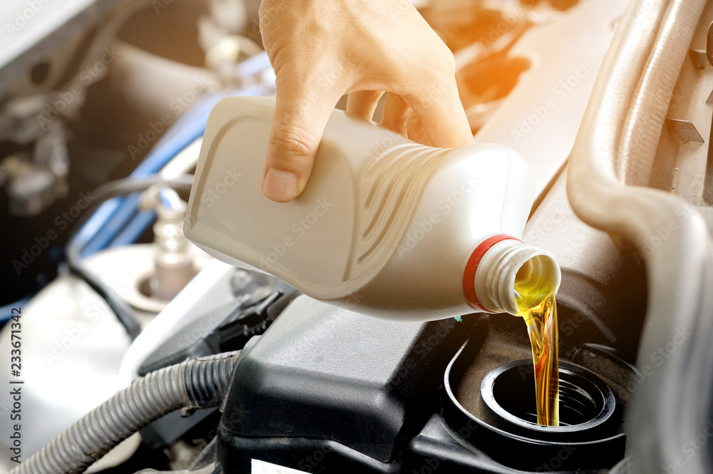 Refueling and pouring oil into the engine motor car. Energy fuel ...