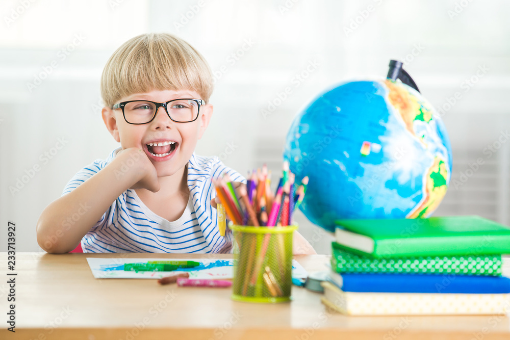 Cute child study at home. Little boy with globe and books indoors ...