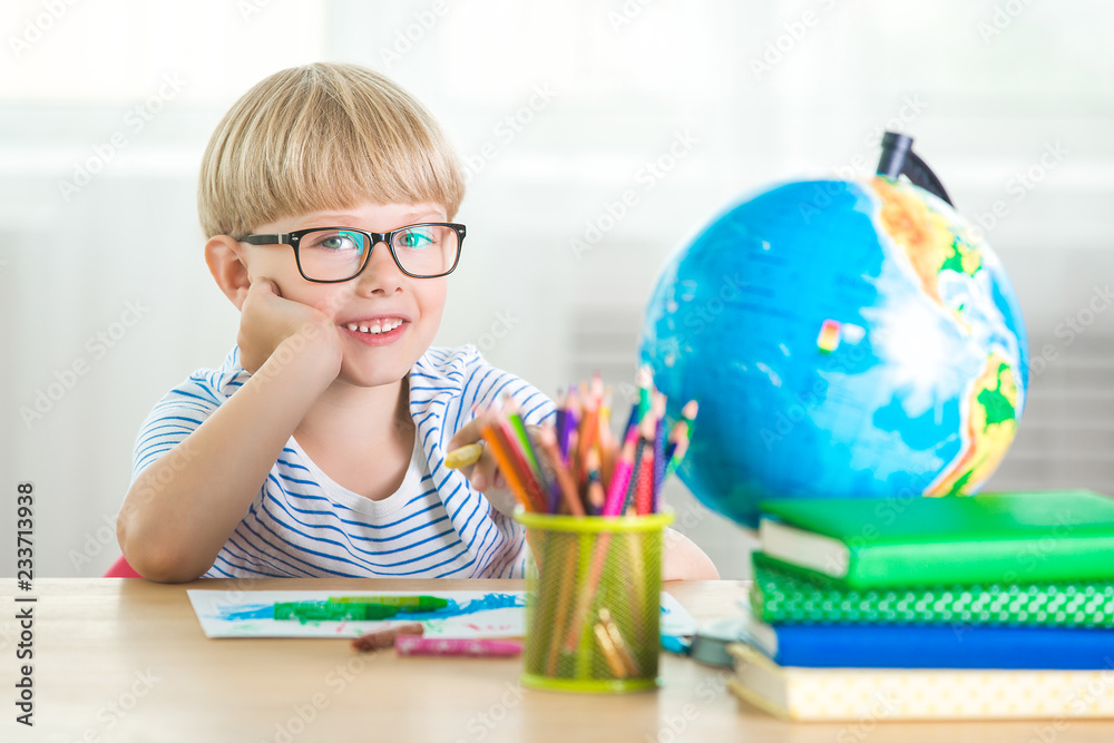 Cute child study at home. Little boy with globe and books indoors ...