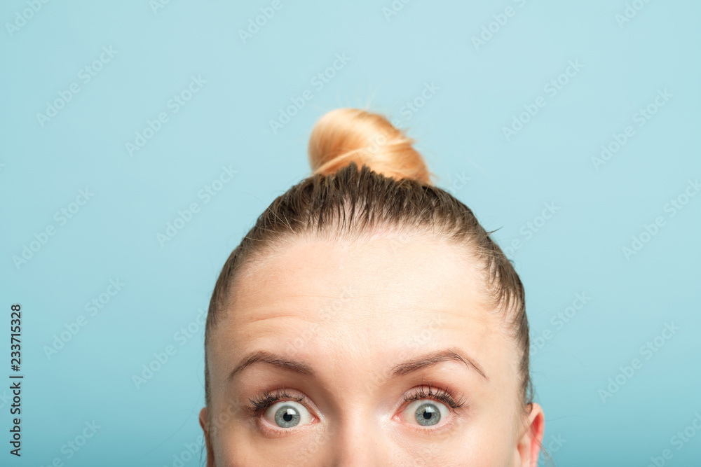 amazed surprised woman face with wide open eyes peeking from the bottom ...