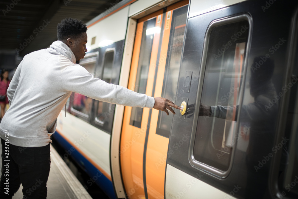 Man pushing a button to open the train doors Stock Photo | Adobe Stock