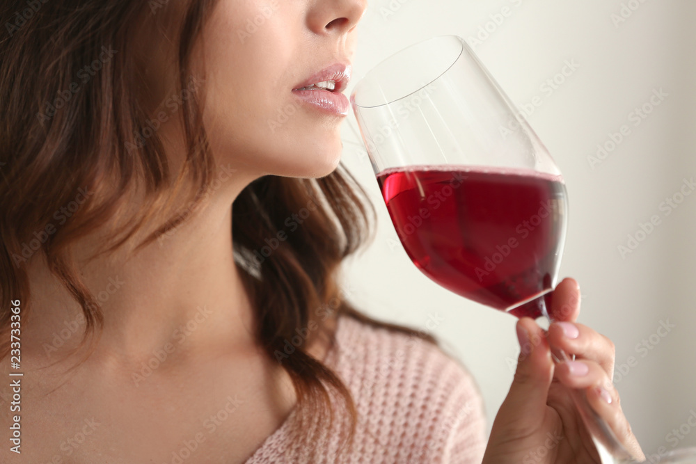 Beautiful young woman drinking wine on light background, closeup Stock ...