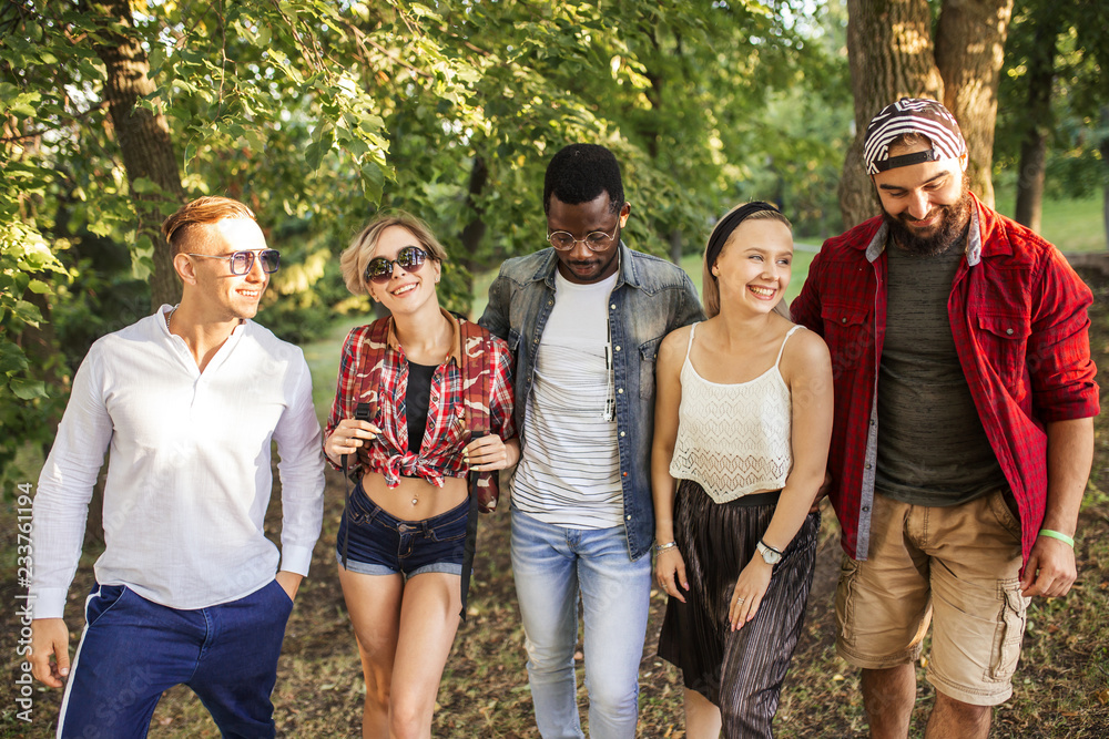 A multiracial group of best friends hanging out together and walking ...