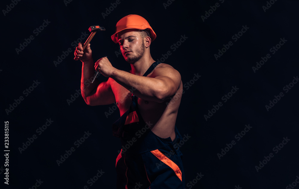 The rest being still under construction. Muscular man builder at work ...