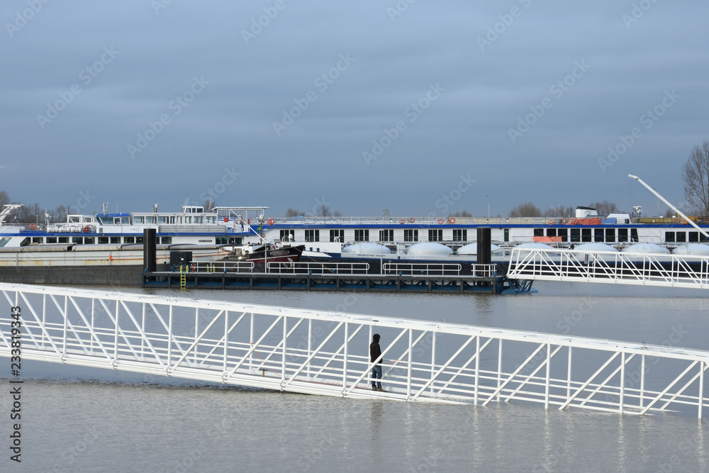 boten en een overstroomde loopbrug door hoogwater in een haven bij de ...