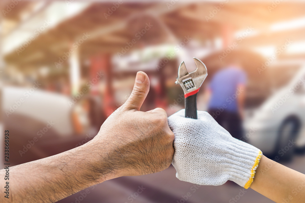 Mechanic hand checking and fixing a broken car in garage.hand of ...