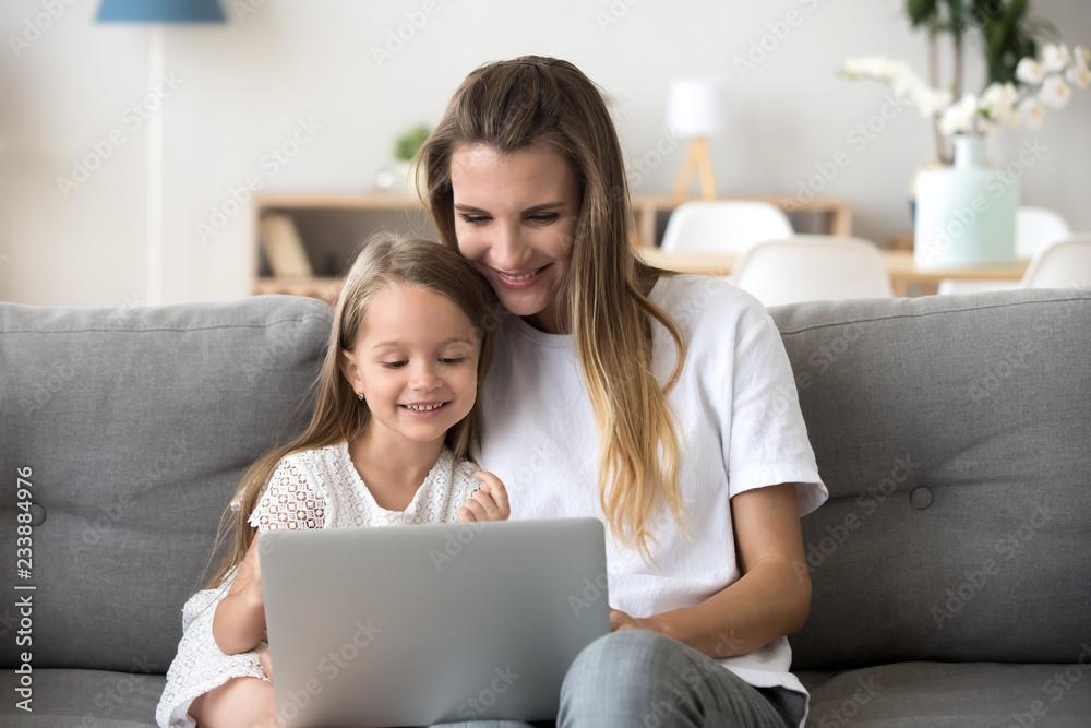 Smiling mother and kid daughter having fun shopping online sitting on ...