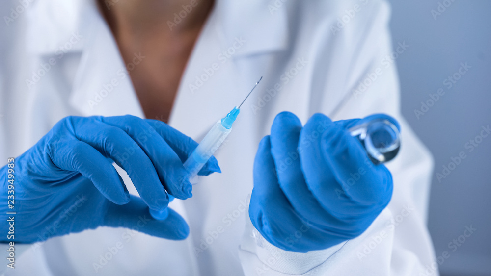 Female doctor holding syringe with medication, first aid, lab vaccine ...