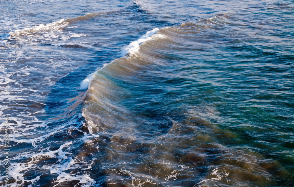 Waves forming before crashing upon a beach with beautiful color in the ...