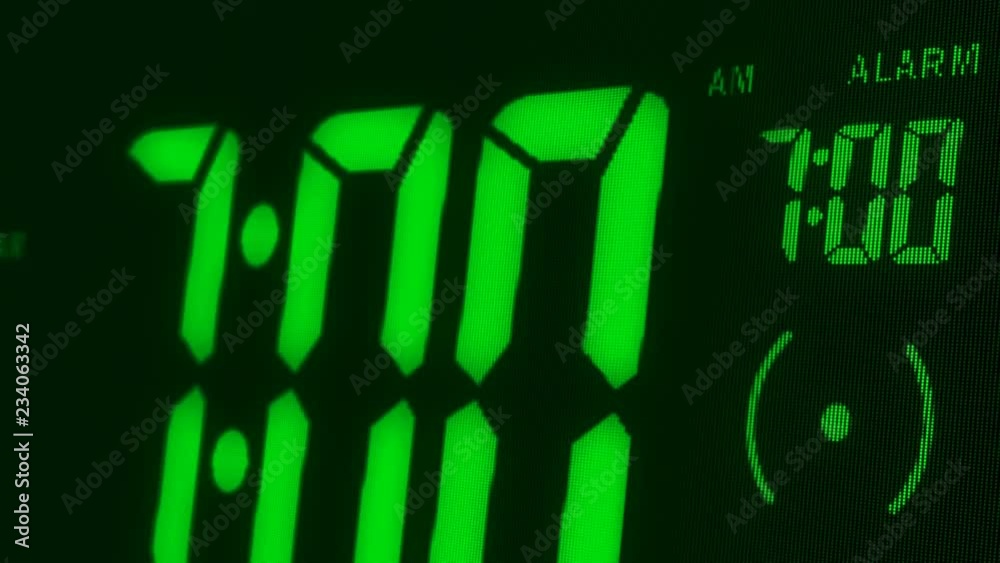 Digital alarm clock waking up at 7 AM. Close-up LED display. The ...