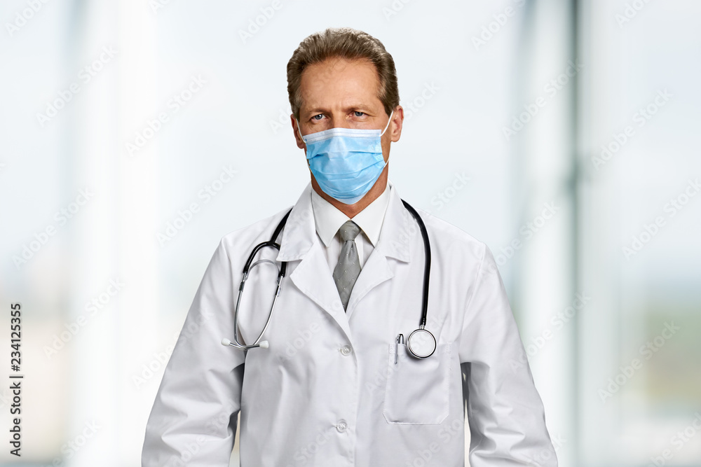 Doctor with face mask and stethoscope. Male caucasian doctor wearing ...