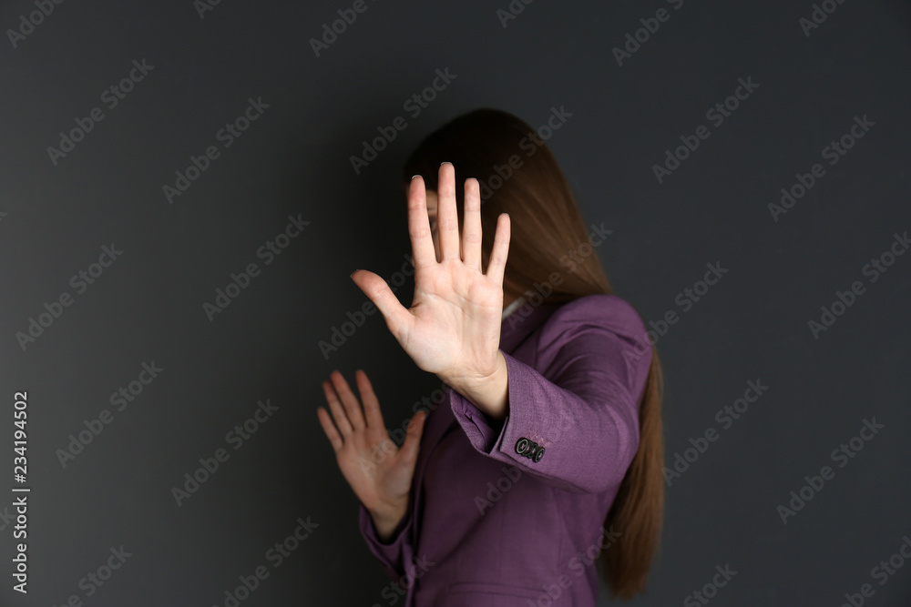 Woman showing stop gesture on dark background. Problem of sexual ...