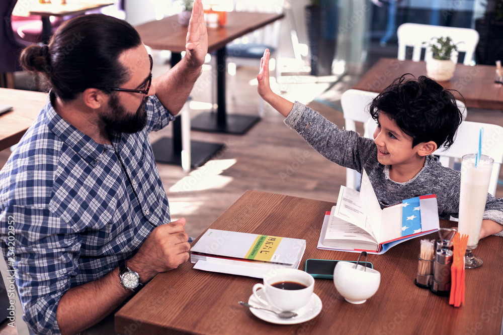 Preschool boy. Cute dark-eyed preschool boy giving high five his ...