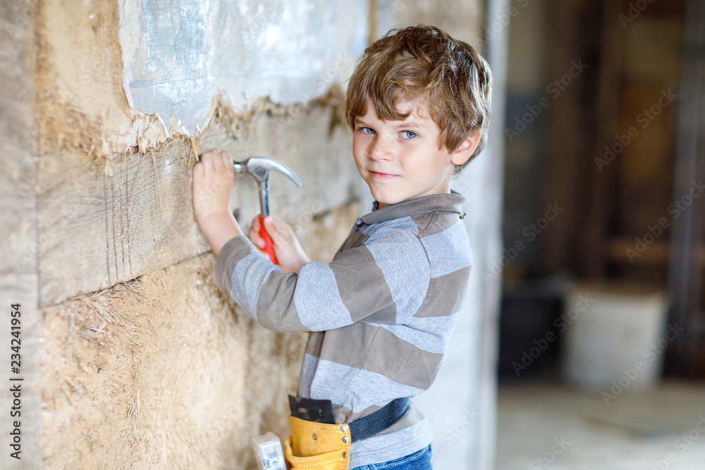 Little kid boy helping with toy tools on construction site. Funny child ...