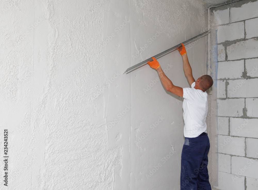 Worker plastering house walls, finishing walls. Wall screeding ...