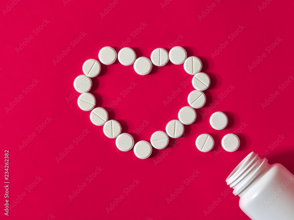Medical white pills in heart symbol on pink background Stock Photo ...