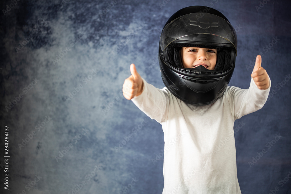 Little kid playing with a motorcycle helmet Stock Photo | Adobe Stock