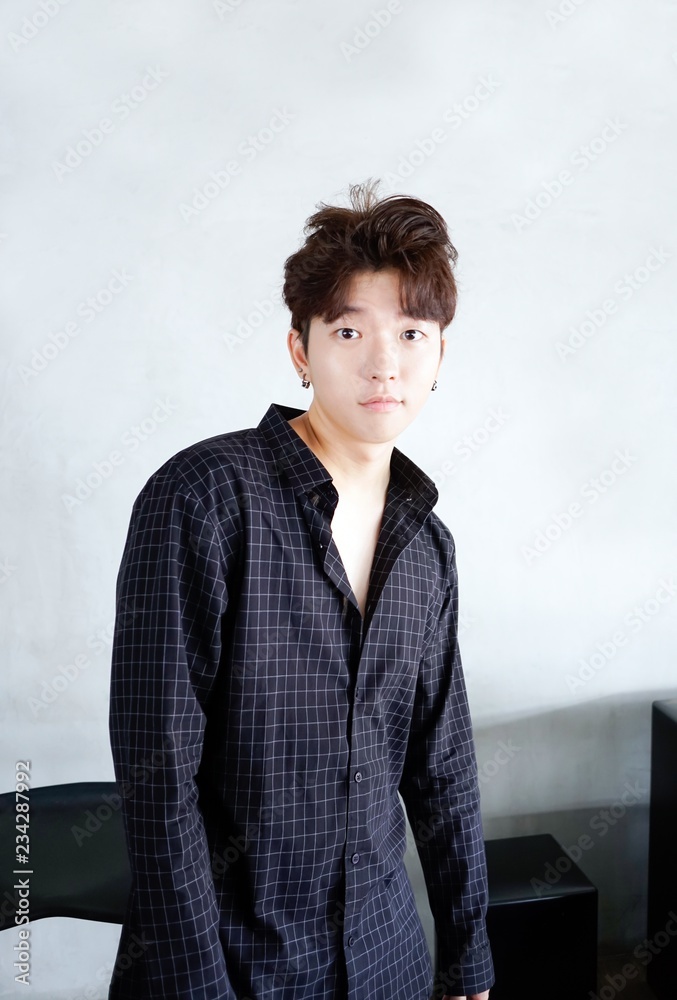 Handsome asian CASUAL man stand and smile posing on gray background ...
