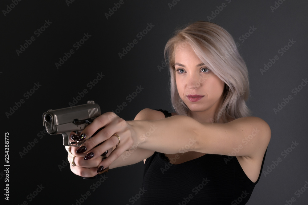 Beautiful woman with gun Stock Photo | Adobe Stock