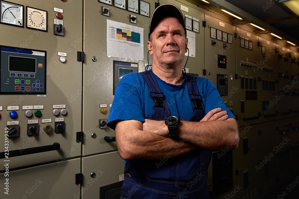 Proud and happy mechanic / chief engineer, posing with his arms crossed ...